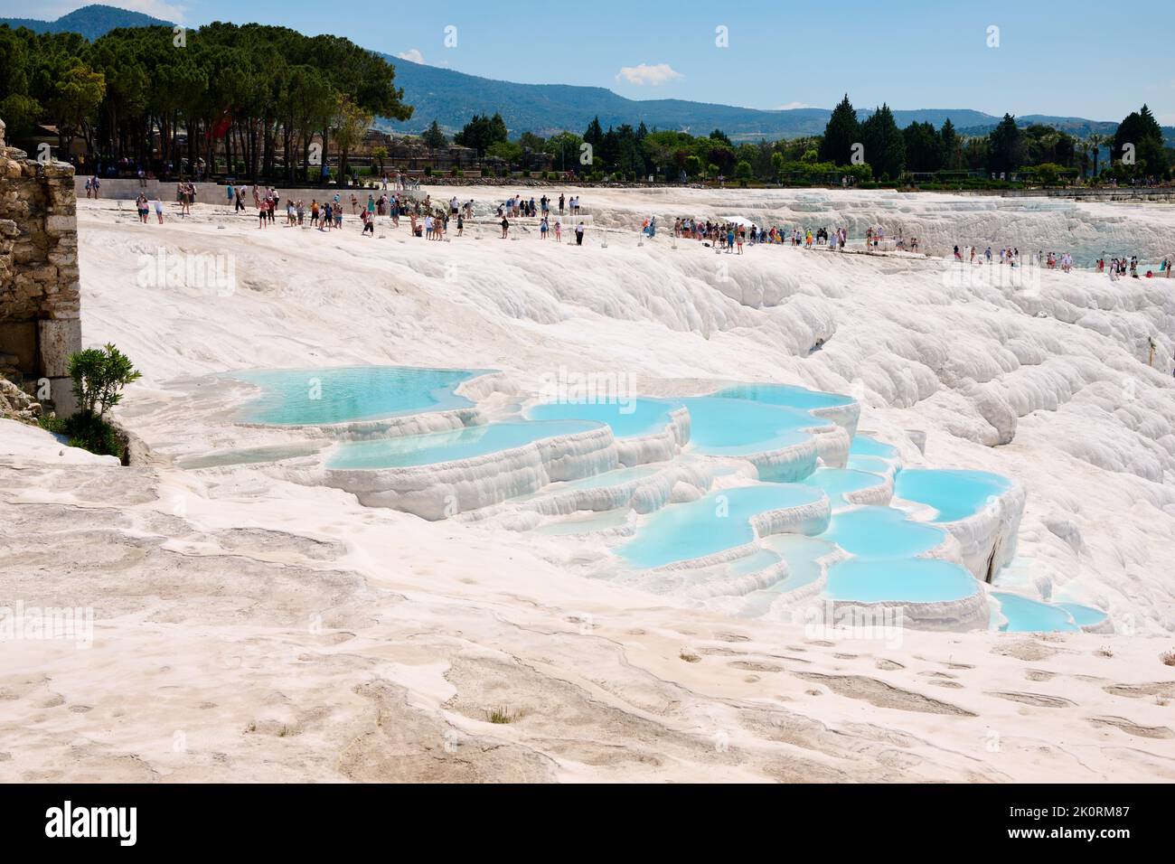 blue pools with water and white travertine terraces of Pamukkale ...