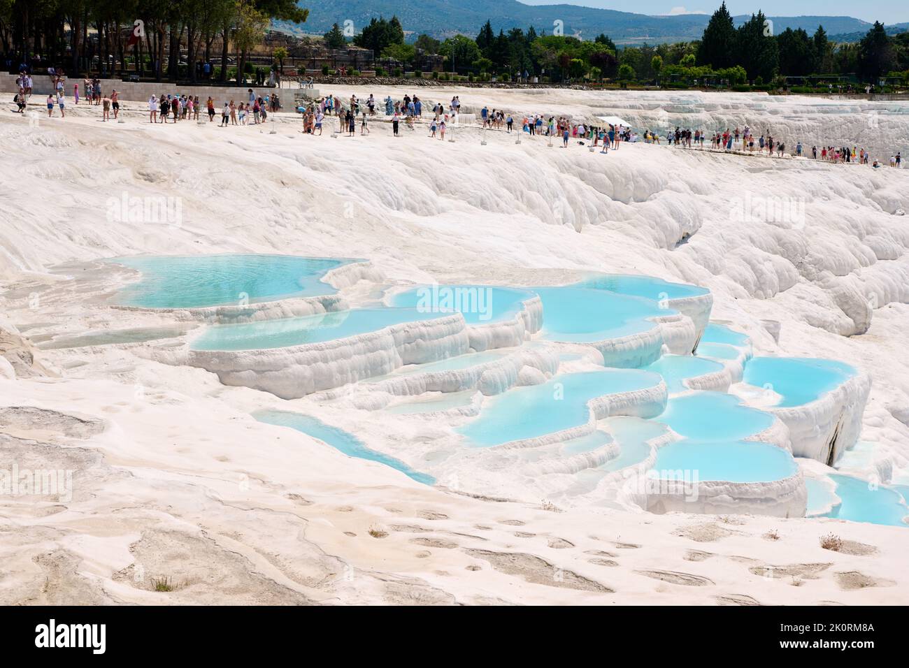 blue pools with water and white travertine terraces of Pamukkale ...