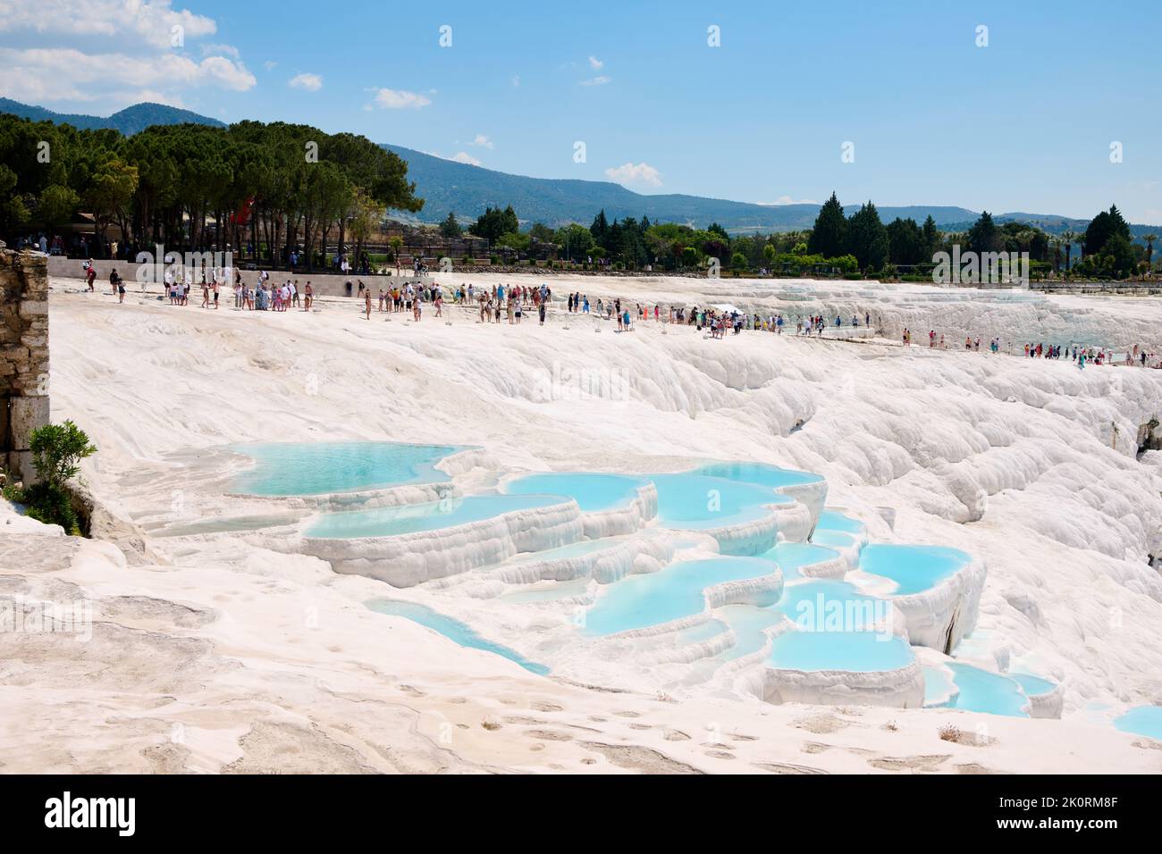 blue pools with water and white travertine terraces of Pamukkale ...
