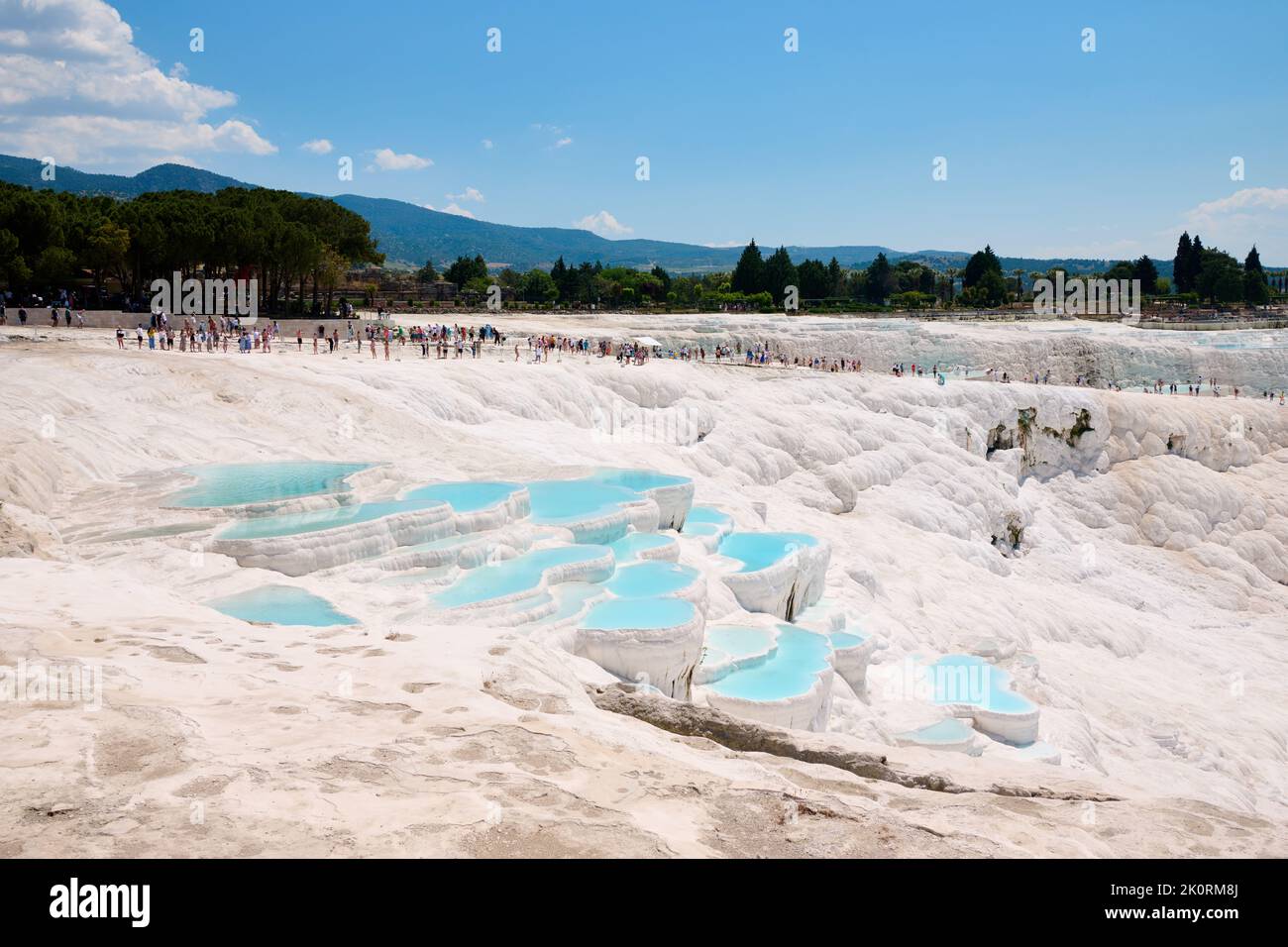blue pools with water and white travertine terraces of Pamukkale ...