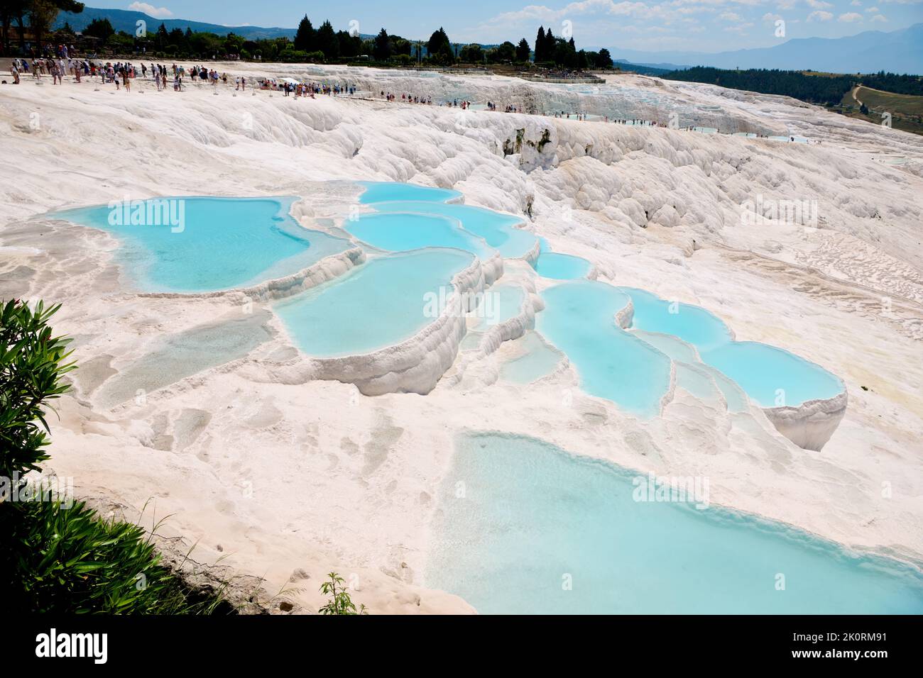 blue pools with water and white travertine terraces of Pamukkale ...