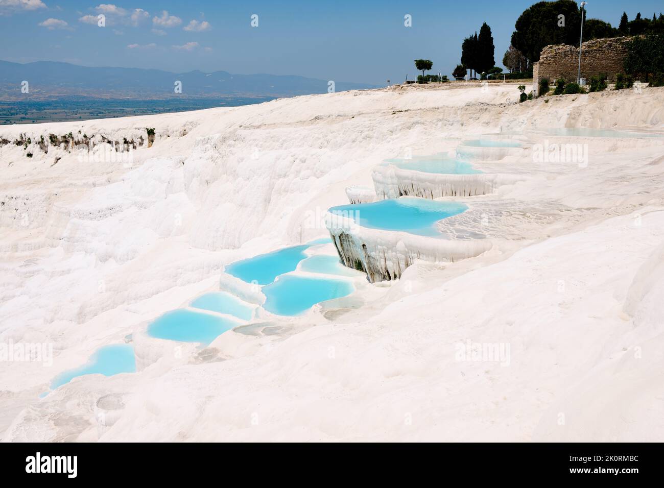 blue pools with water and white travertine terraces of Pamukkale ...