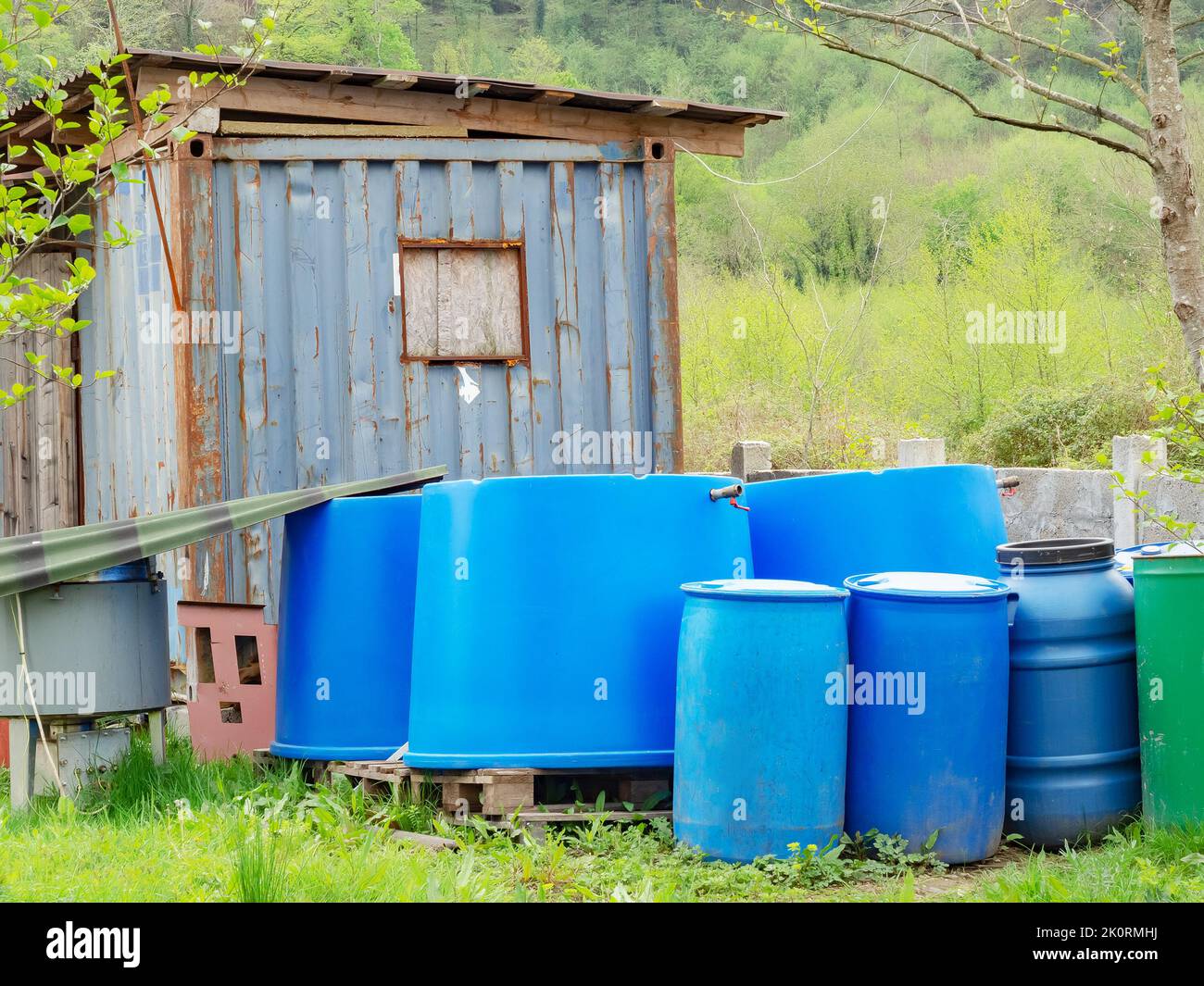 Blue cisterns in the yard. Blue water cisterns by barn Stock Photo - Alamy
