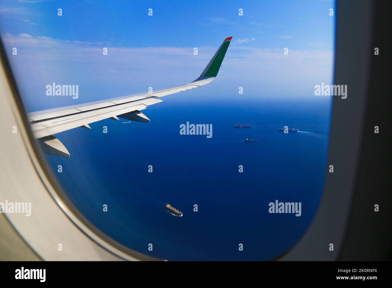View from airplane window with blue sky and ocean background Stock ...