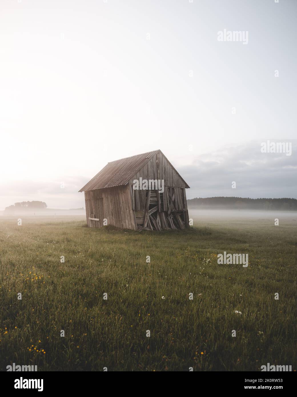A vertical shot of a damaged wooden hut in the meadow Stock Photo - Alamy
