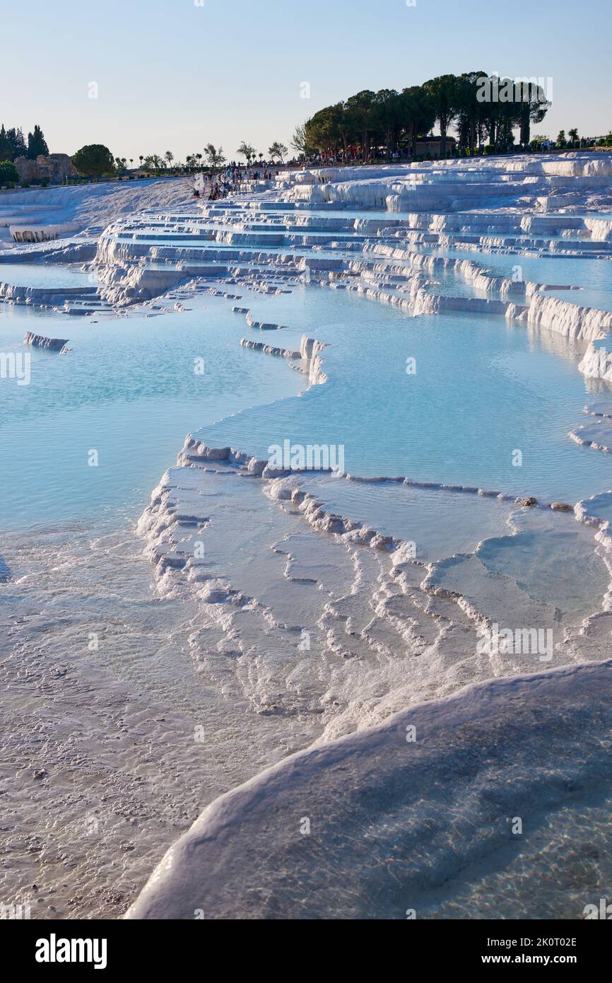 blue pools with water and white travertine terraces of Pamukkale ...