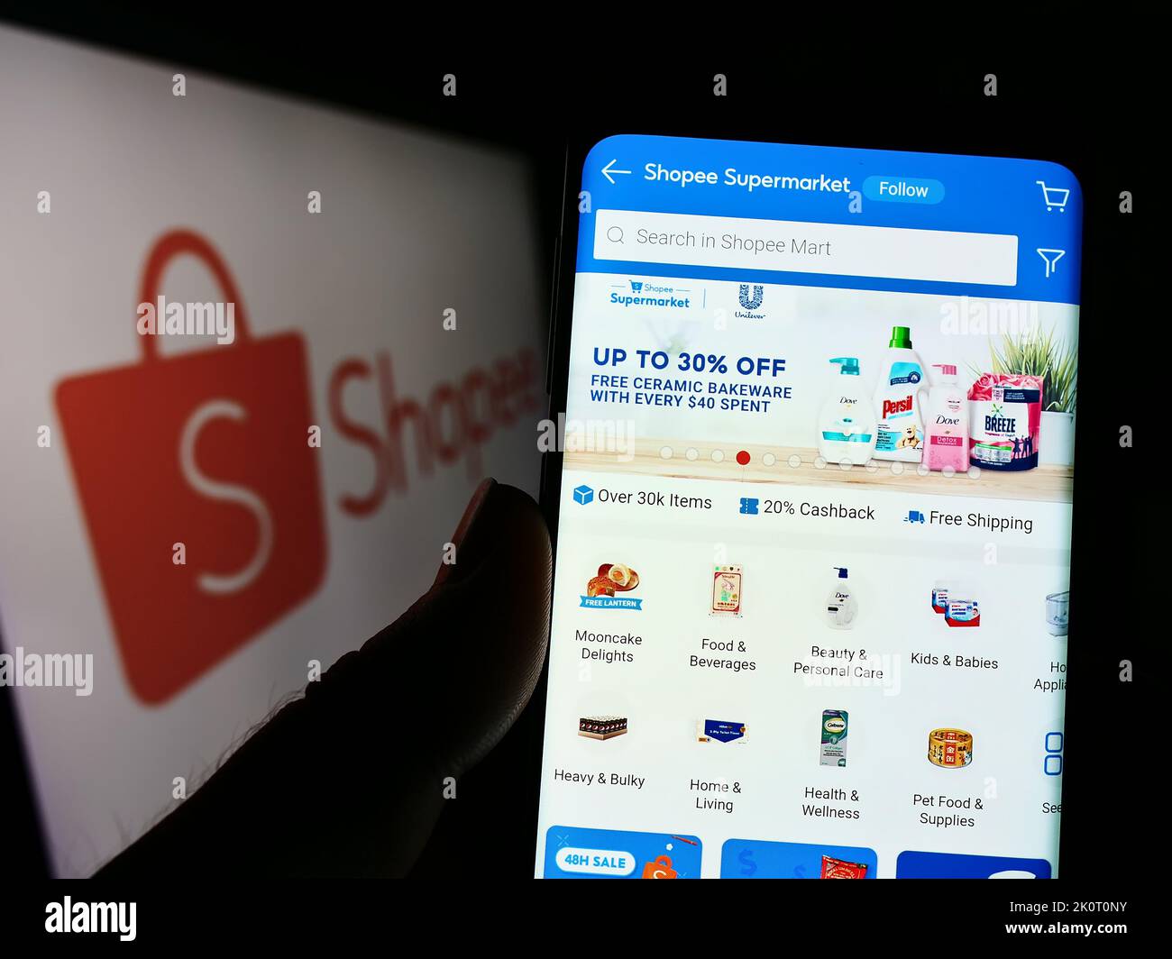 Person holding smartphone with webpage of Singaporean e-commerce ...