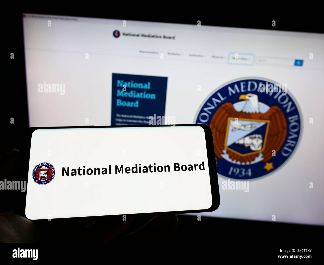 Person holding mobile phone with logo of American agency National ...