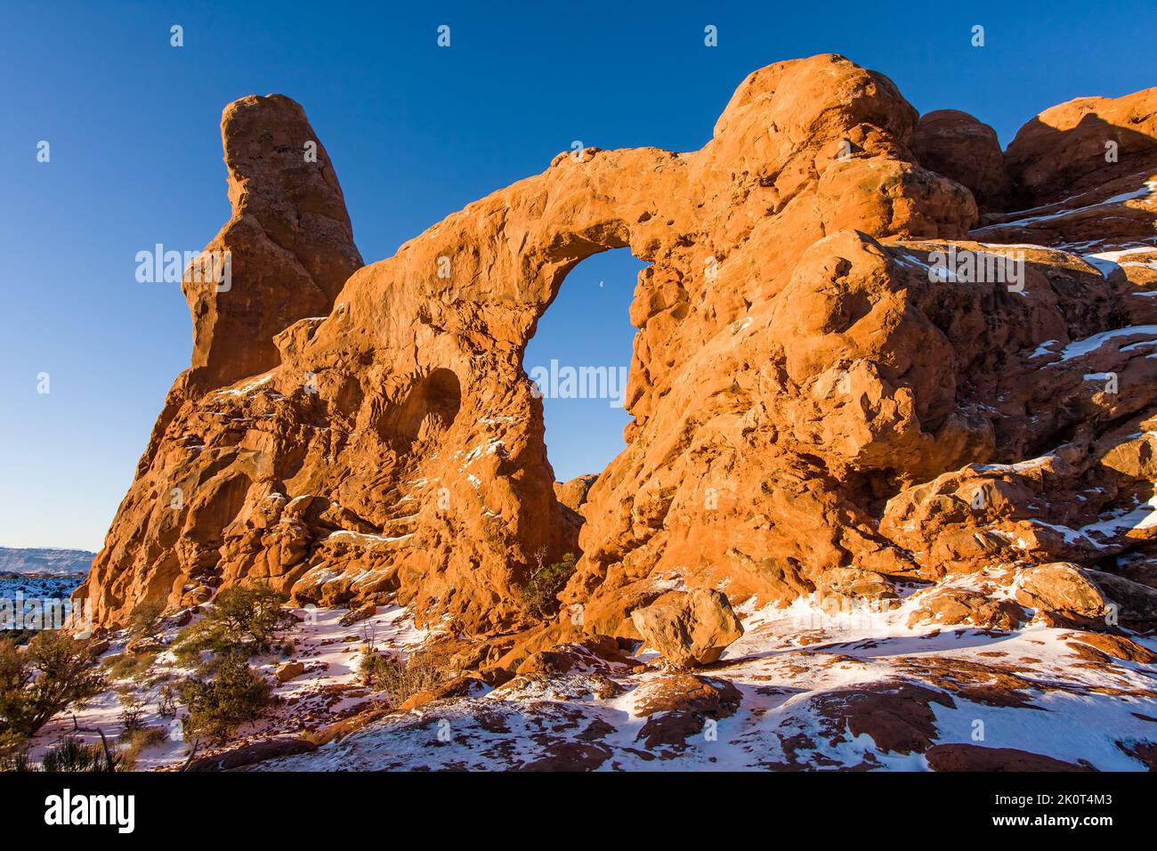 Half moon framed by Turret Arch with snow in winter in the Windows ...