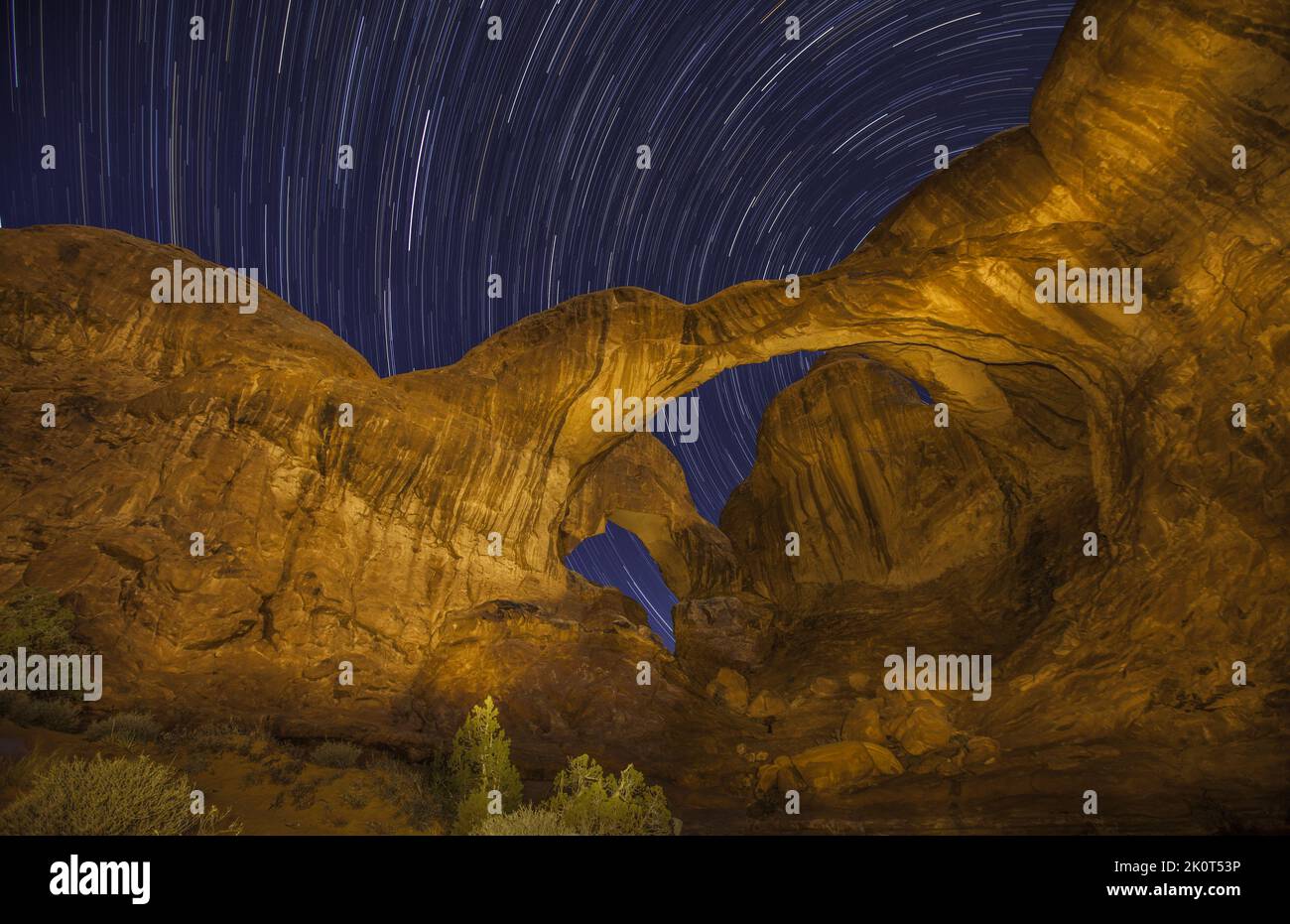 Star trails over Double Arch at night with artificial light painting ...