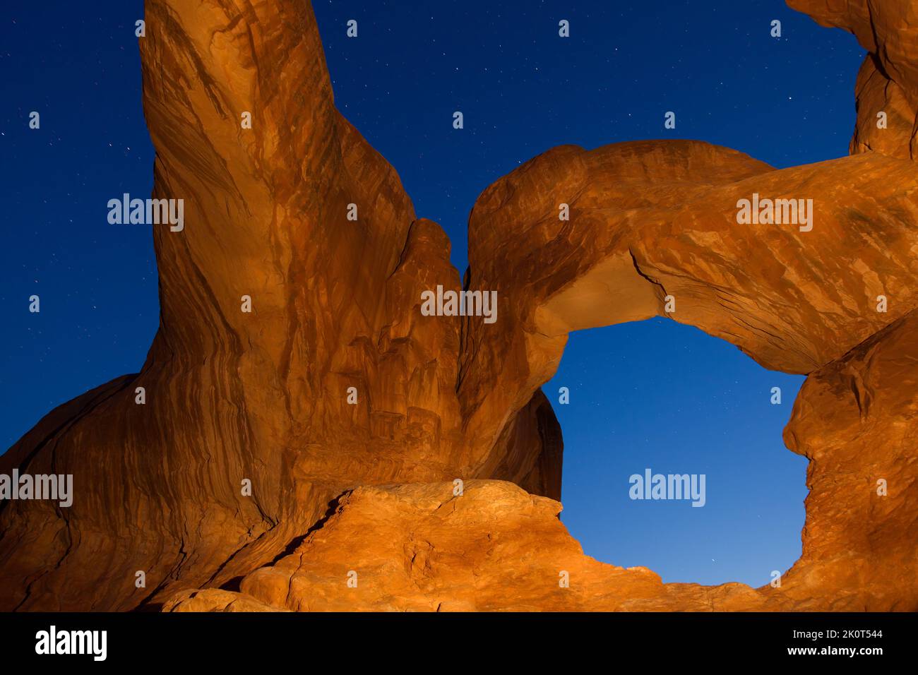 Double Arch at night with stars and artificial light painting with a ...