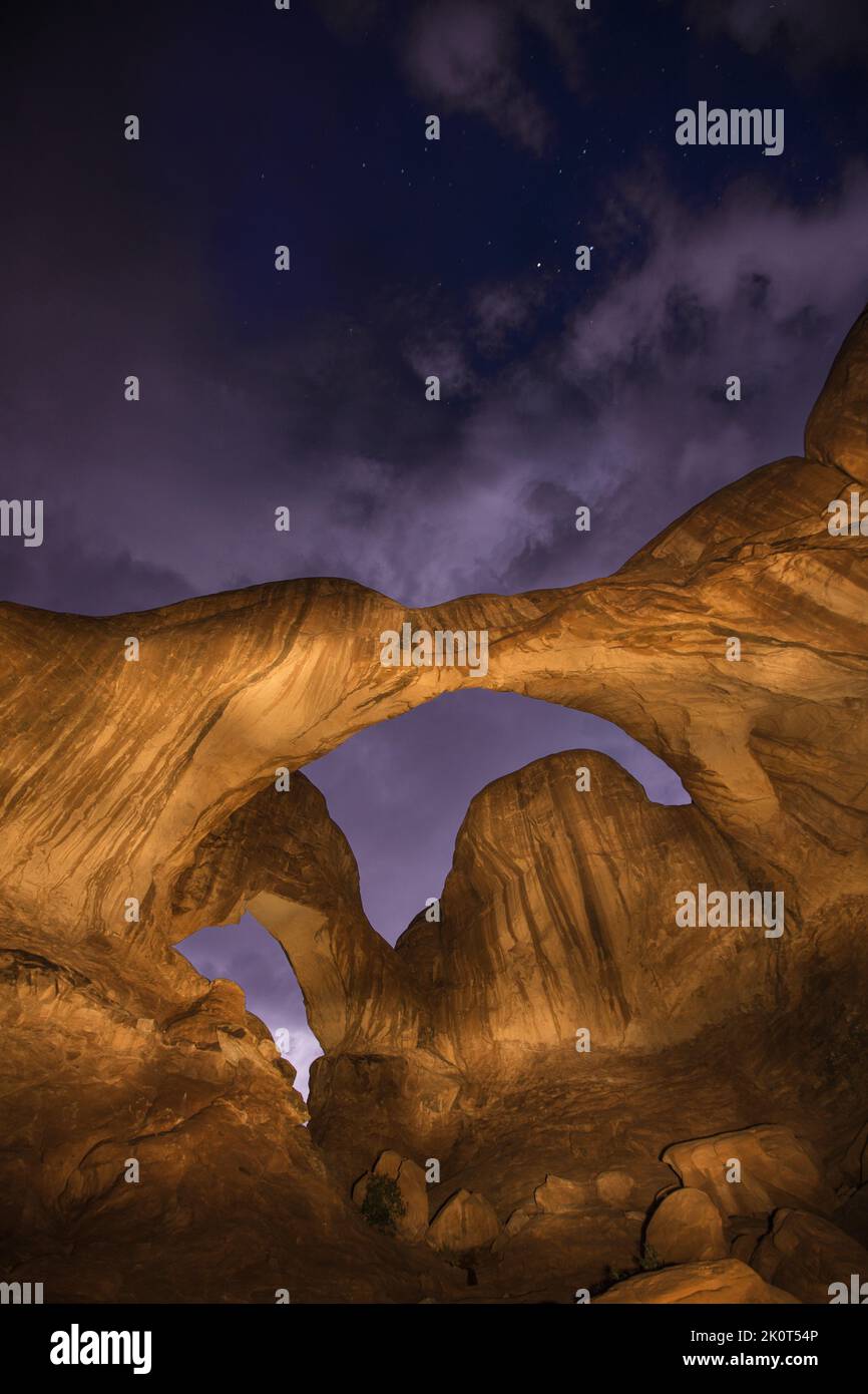 Double Arch at night with stars and artificial light painting with a ...