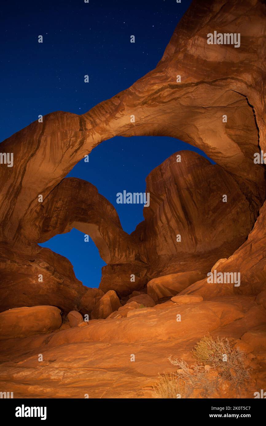 Double Arch at night with stars and artificial light painting with a ...