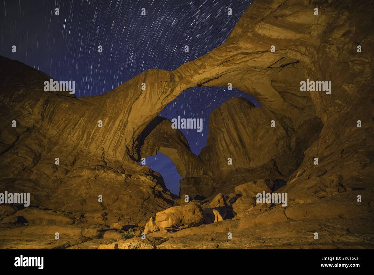 Short star trails over Double Arch at night with artificial light ...