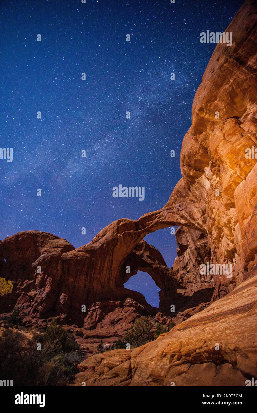 Double Arch at night with the MIlky Way, lit by the moon and light ...