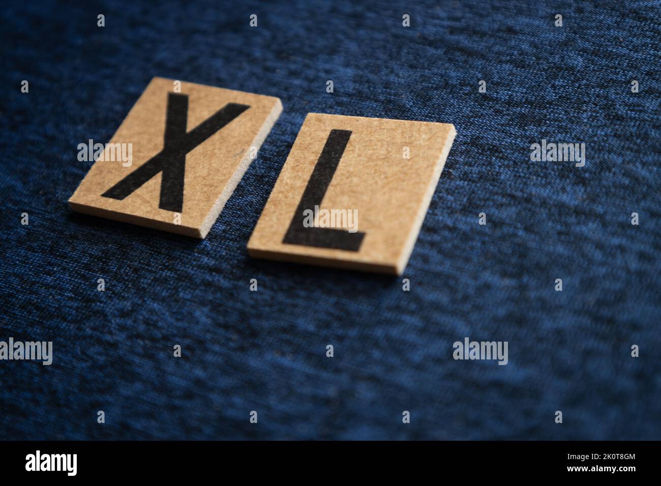 Sign with the acronym XL on a blue cloth symbolizing extra large size ...