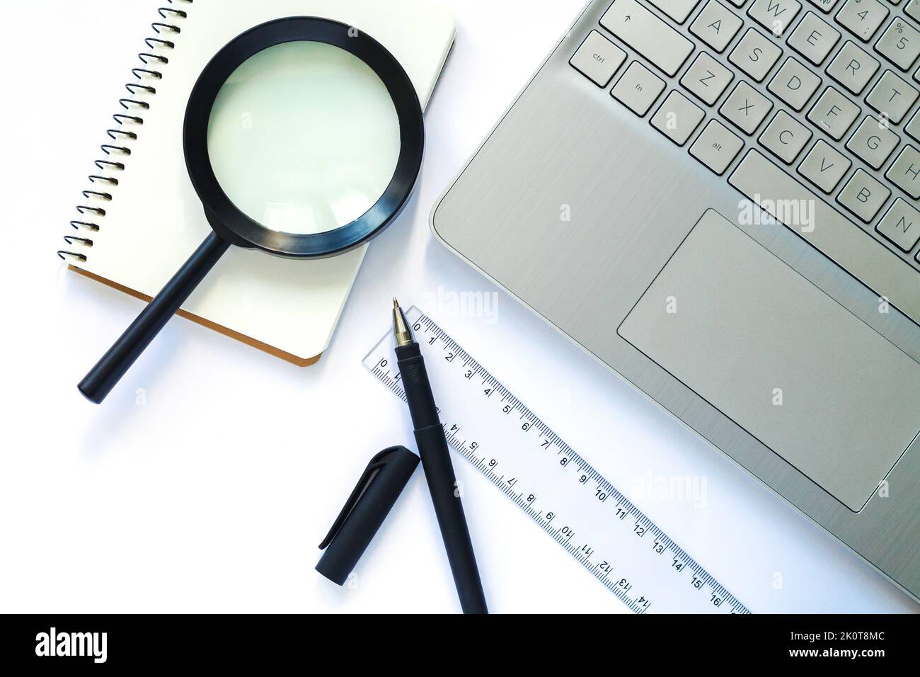 Business background with laptop, notepad, pen, ruler and magnifying ...