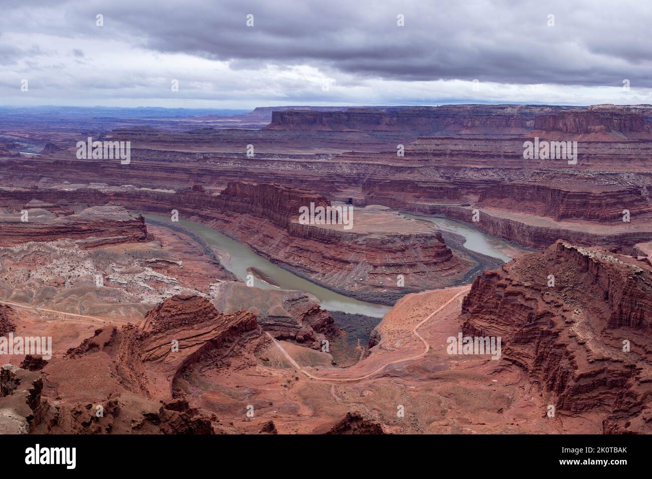 The Colorado River and White Rim Road twisting and winding below layers ...