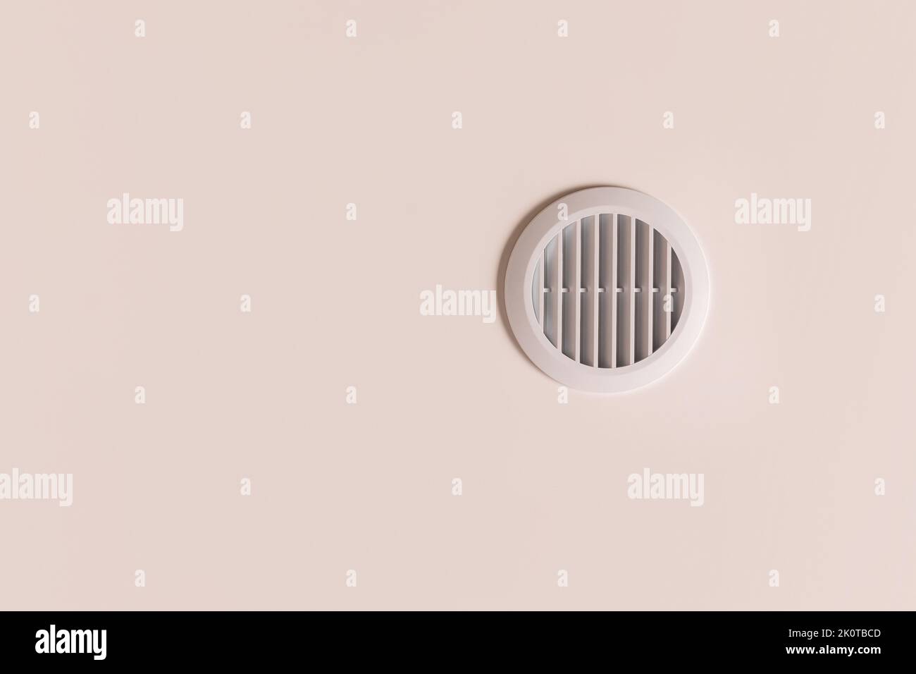 Round air vent with white plastic grate on beige ceiling Stock Photo ...