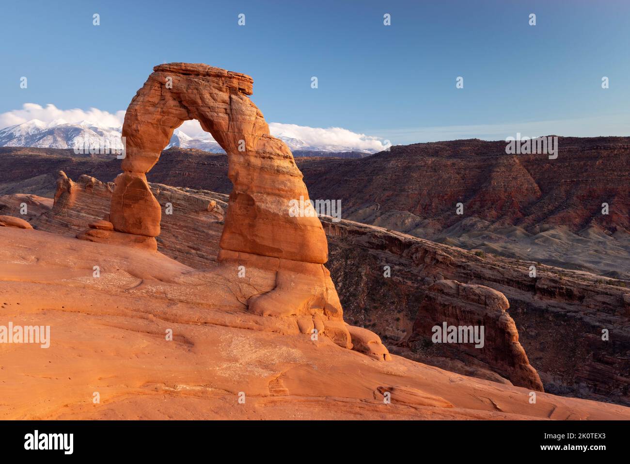 Delicate Arch rising high above nearby sandstone buttes and ridges in ...