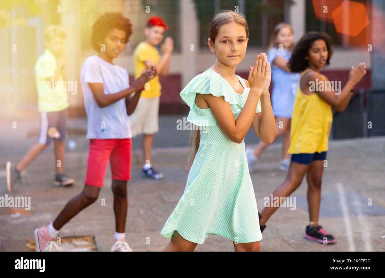 Happy girl dancing with group of tweenagers on city street Stock Photo ...