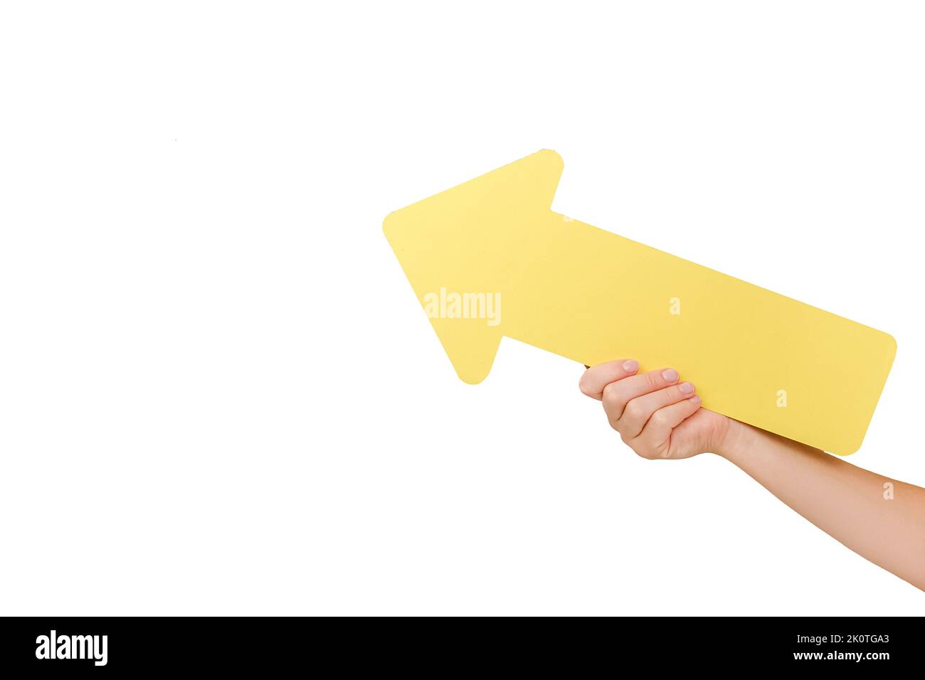 Close up of female hand holding big yellow paper arrow pointer on copy ...