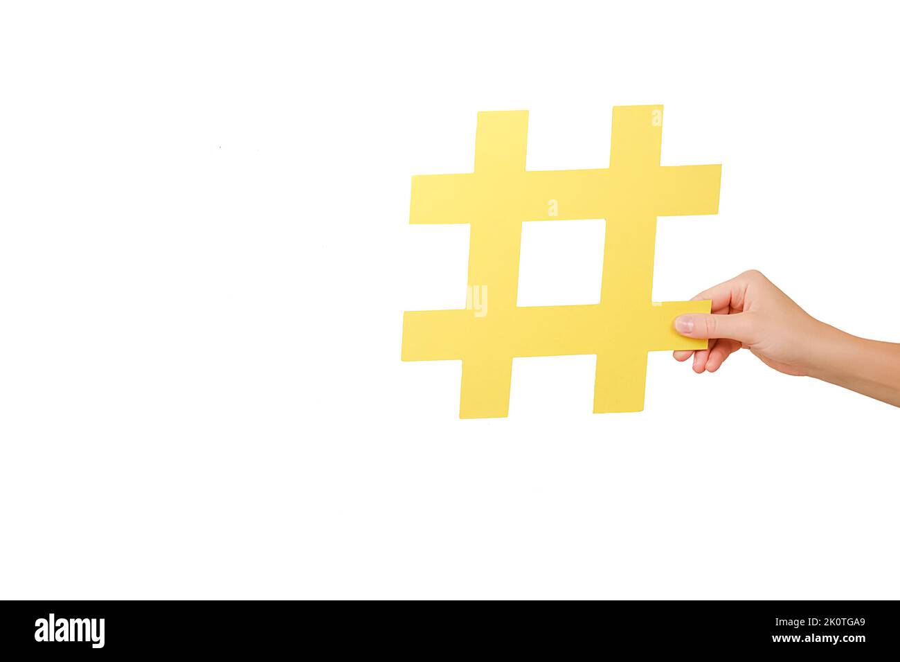 Close up of woman hand holding large yellow paper hashtag symbol, hash ...