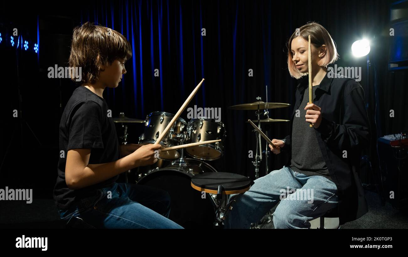 Young woman teaching boy to play drums Stock Photo - Alamy