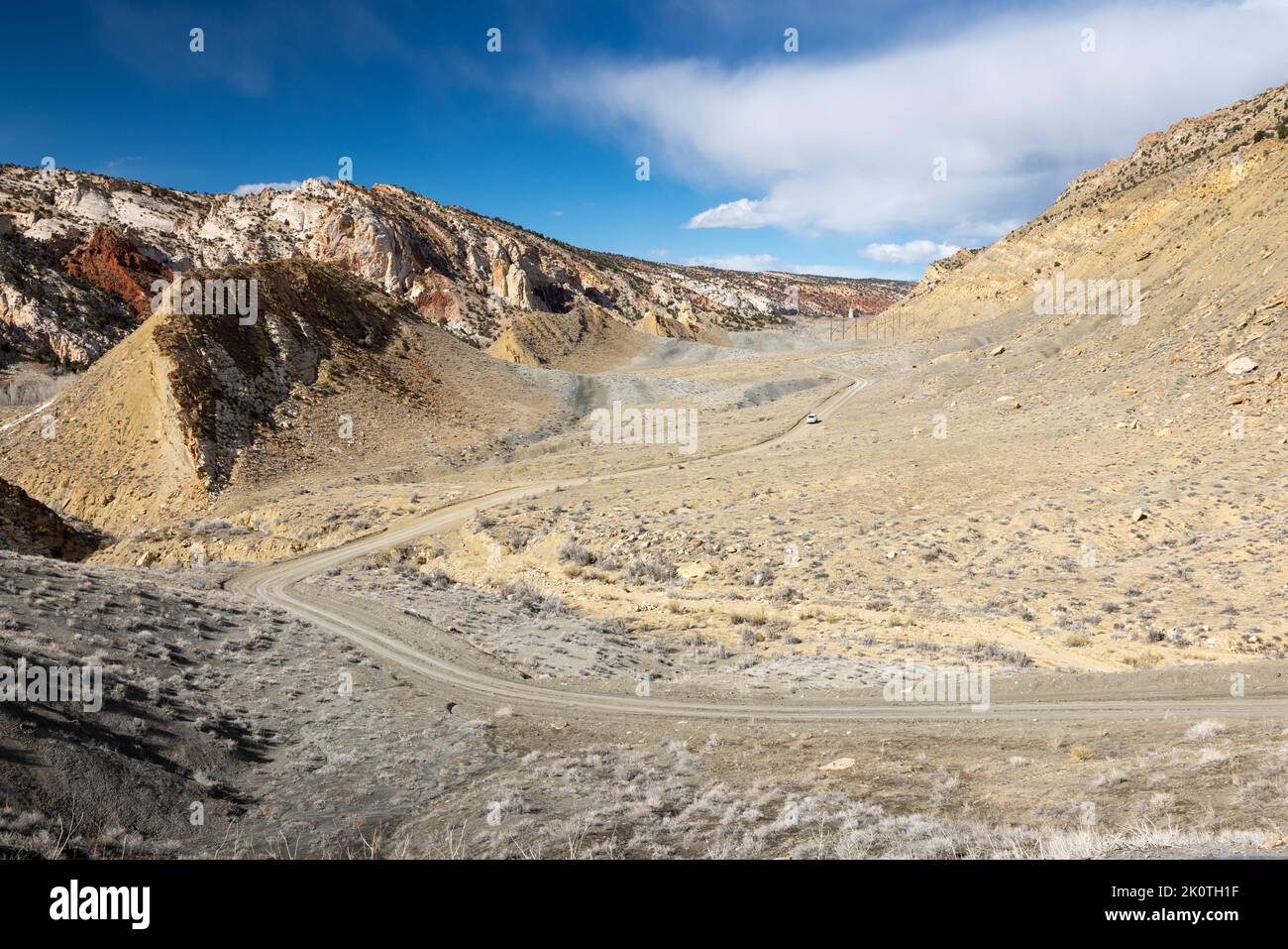 A car driving along Cottonwood Canyon Road below the Cockscomb. Grand ...