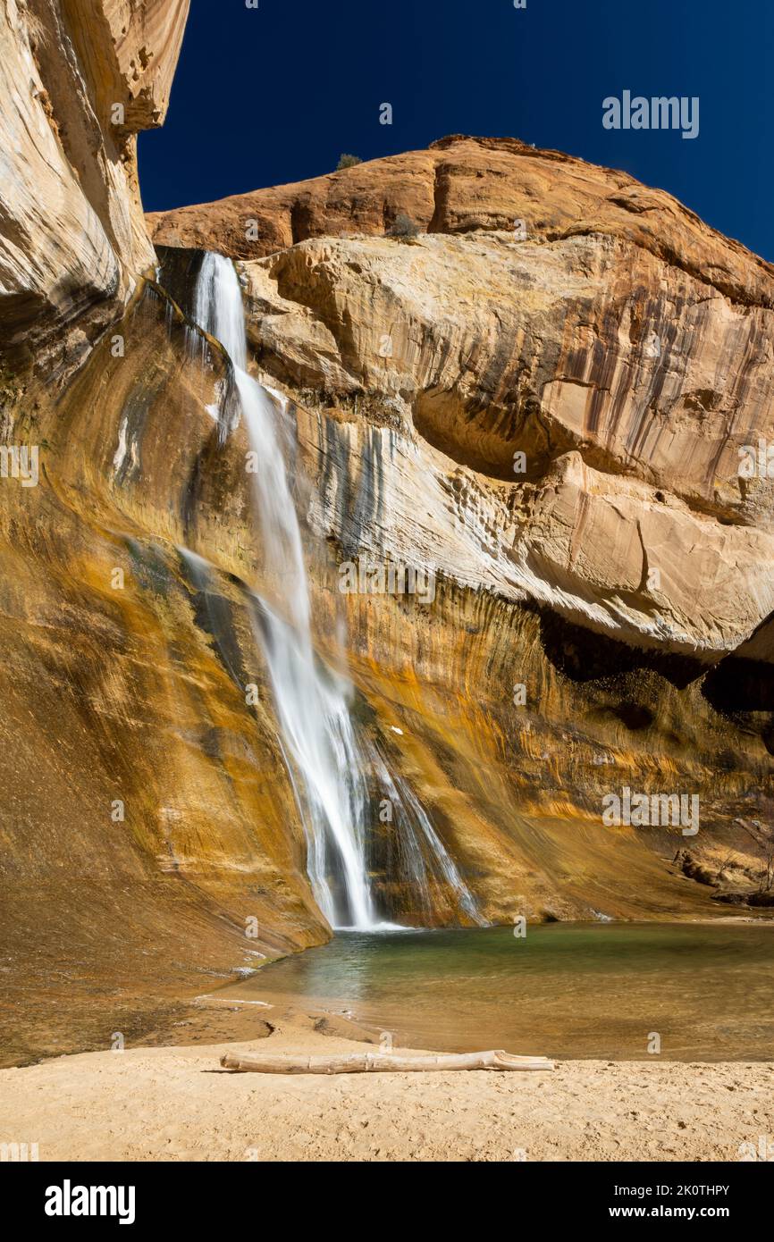 Lower Calf Creek Falls pouring over a large sandstone cliff into a pool ...