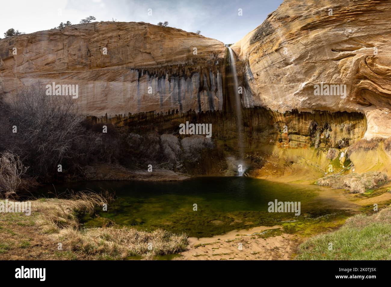 Upper Calf Creek Falls pouring over sandstone cliffs and into a large pool below. Grand ...