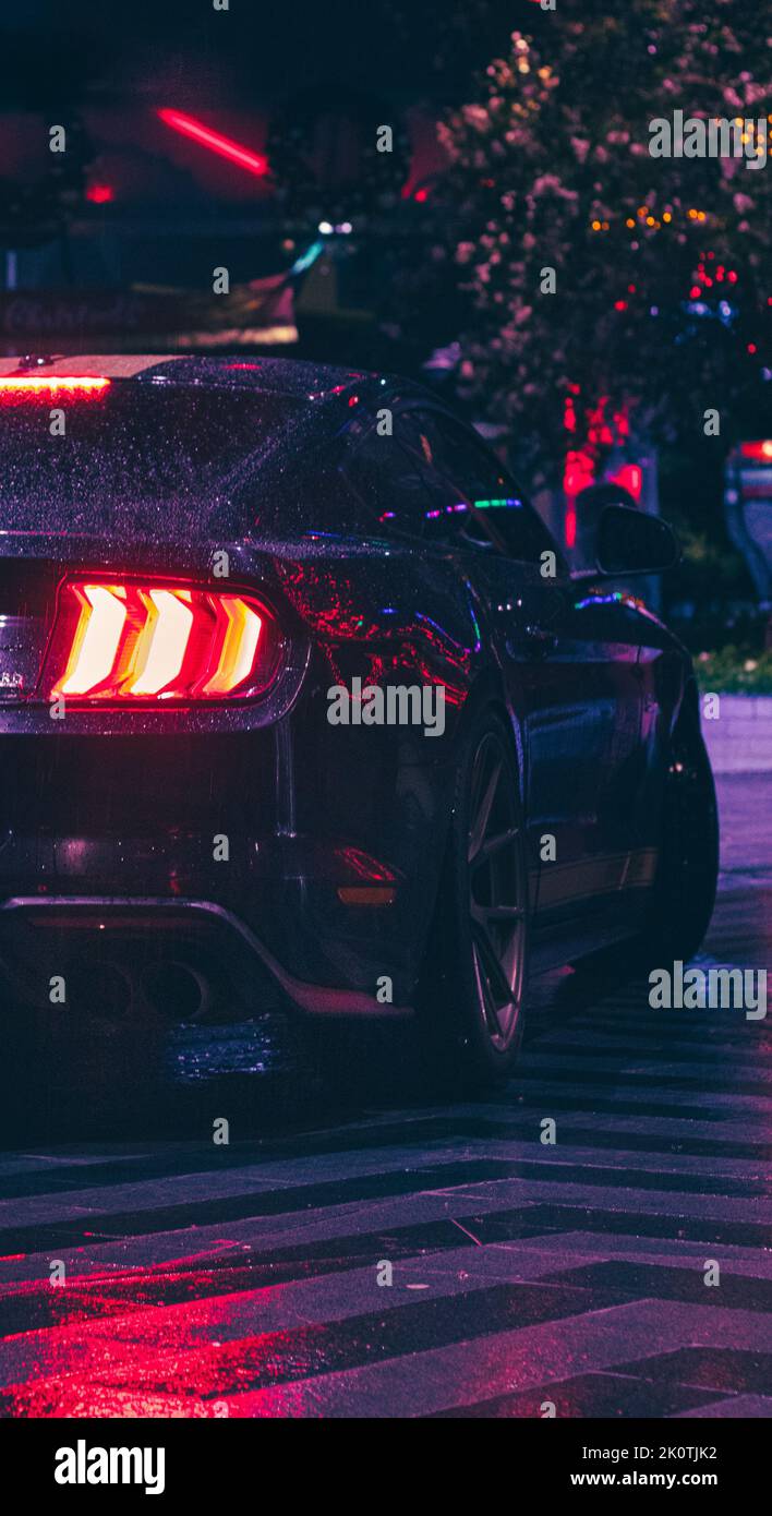 A vertical back view of a modern black car under the rain Stock Photo ...