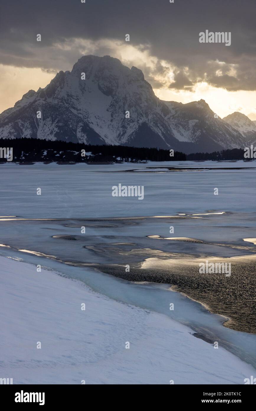 Mount Moran rising high above Jackson Lake as it begins to thaw from ...