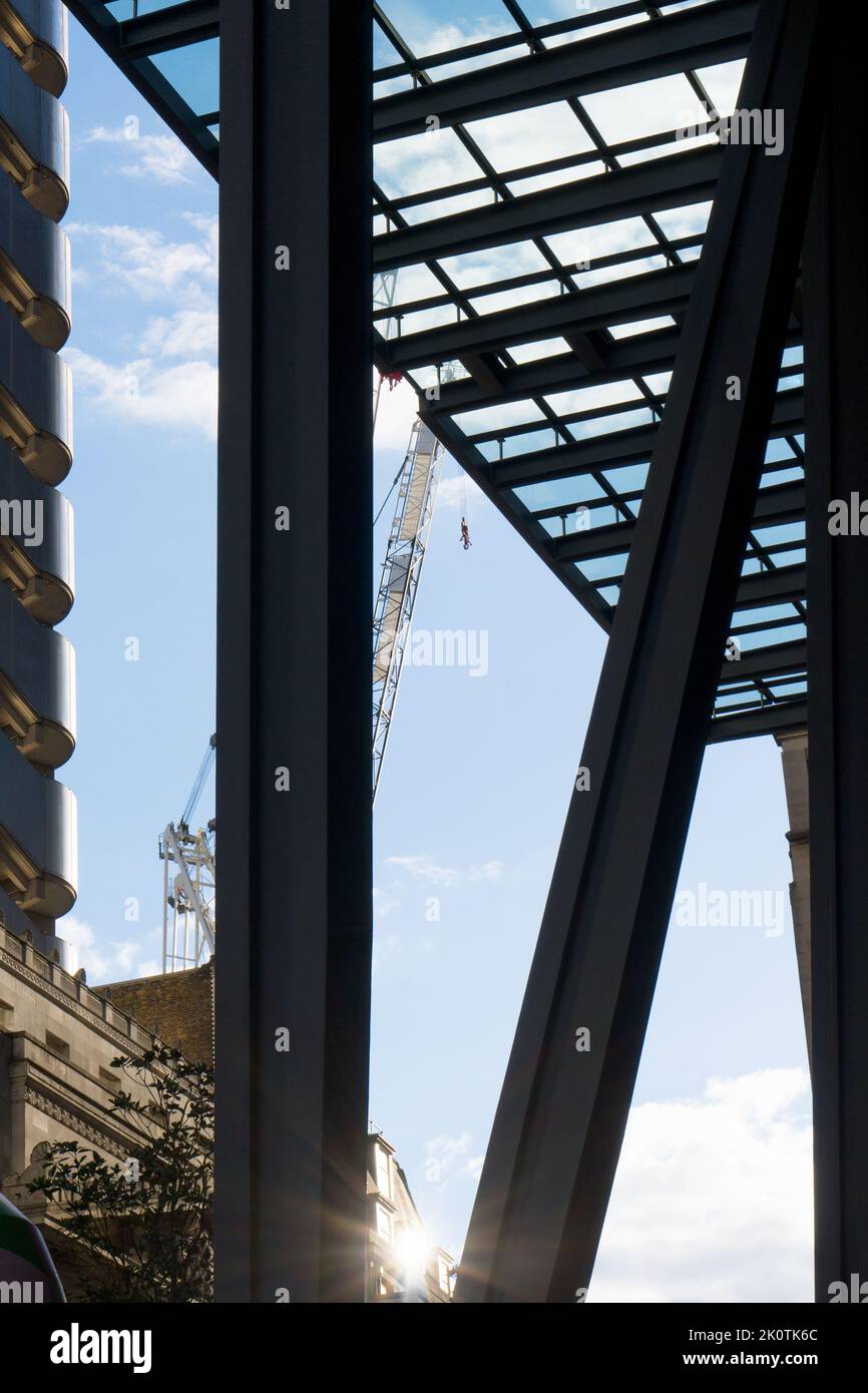 Looking up between massive steel beams at a tower crane at the ...