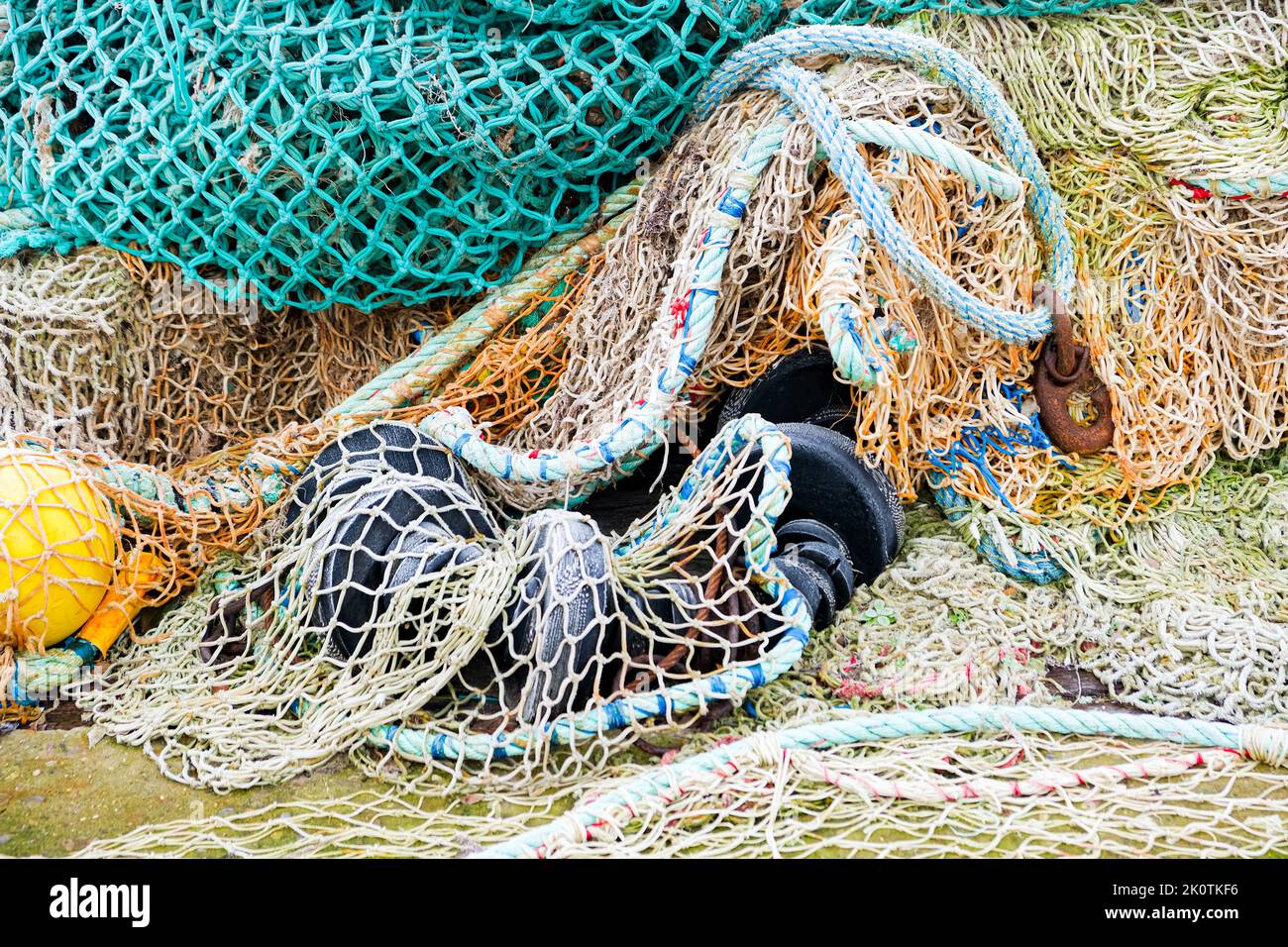 blue fishing net on a pontoon with its ropes and floats covered with ...