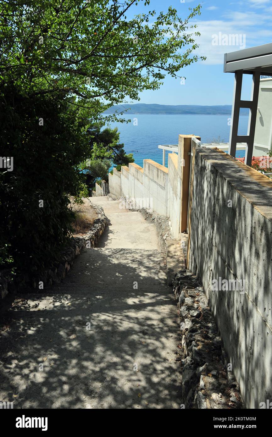 Vertical photo of narrow alley and stairs to the beach of Brela in ...