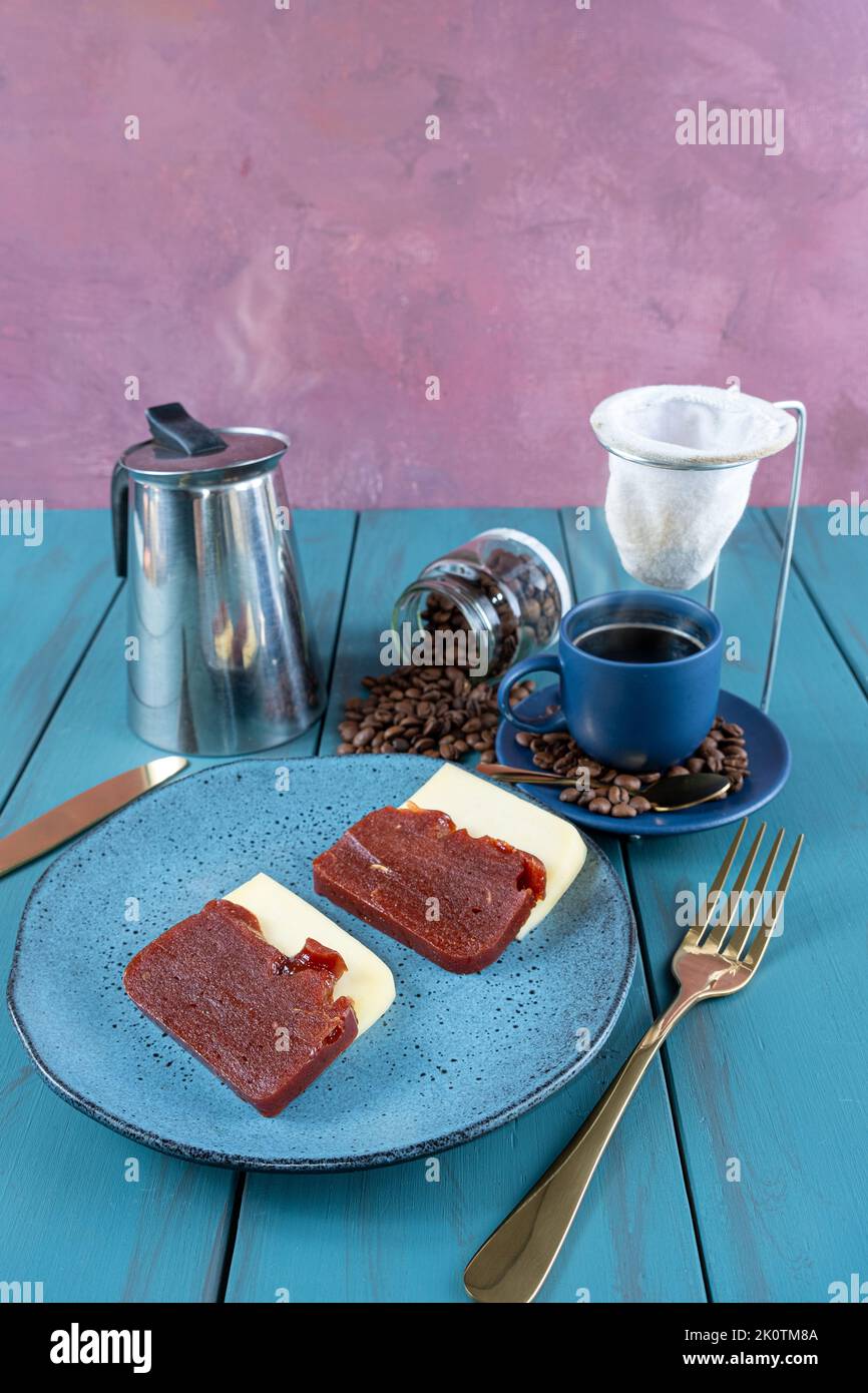 Guava sweet with cheese surrounded by cutlery, cup and coffee beans on ...