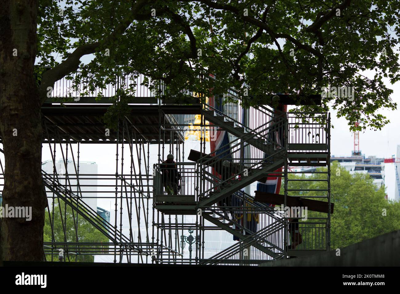 Temporary structures and workers are silhouetted against the Victoria ...