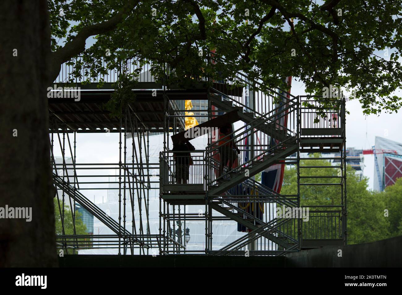 Temporary structures and workers are silhouetted against the Victoria ...