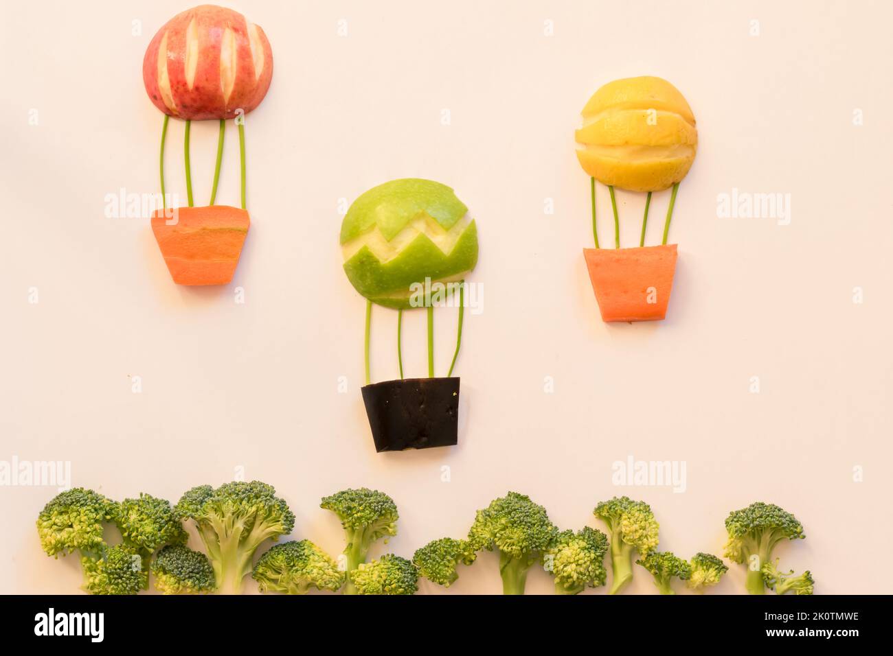 flying balloon made from apples,broccoli and carrots, isolated colorful ...