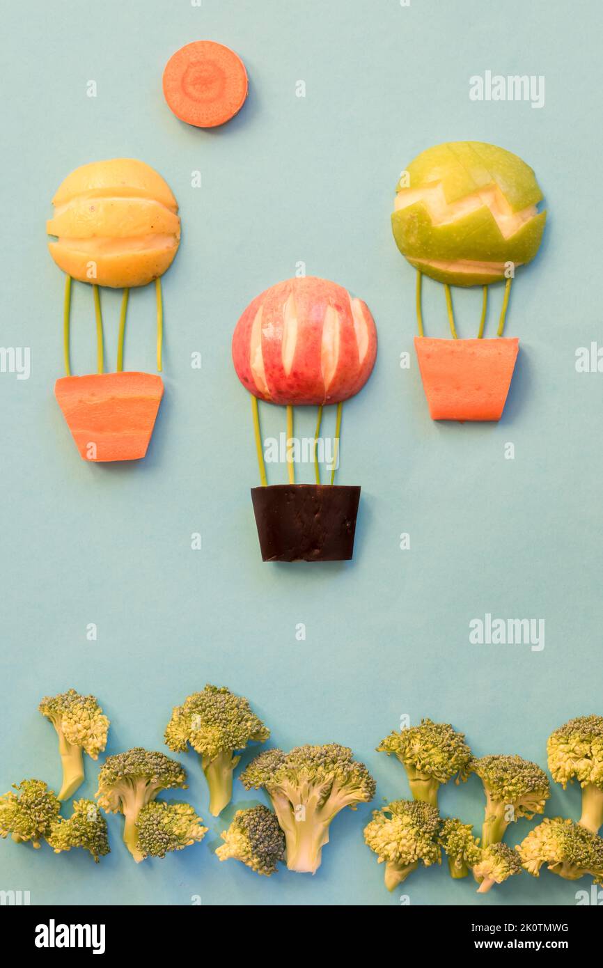 flying balloon made from apples,broccoli and carrots, isolated colorful ...