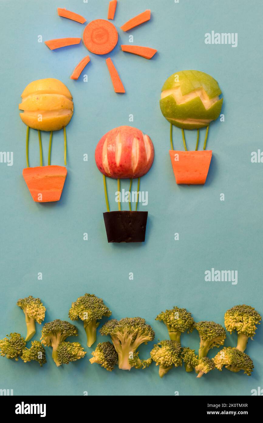 flying balloon made from apples,broccoli and carrots, isolated colorful ...