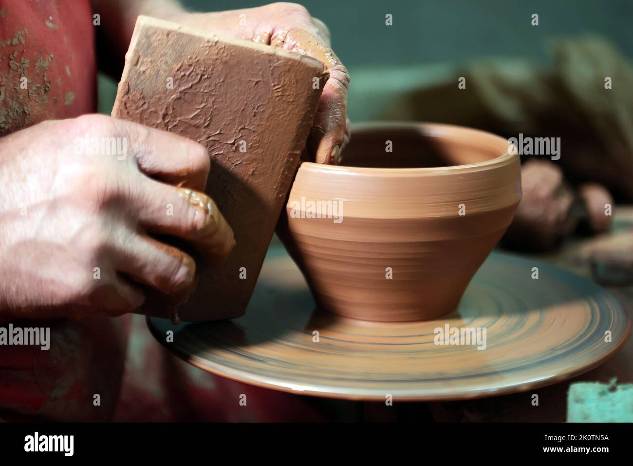 KOSIV, UKRAINE - SEPTEMBER 9, 2022 - A craftsman shapes a piece of clay ...