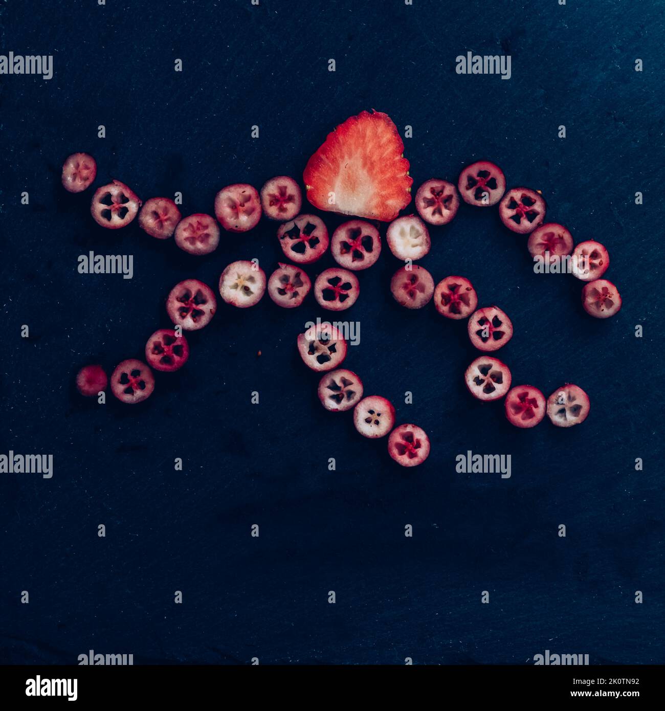 octopus made from red fruits on black background Stock Photo - Alamy