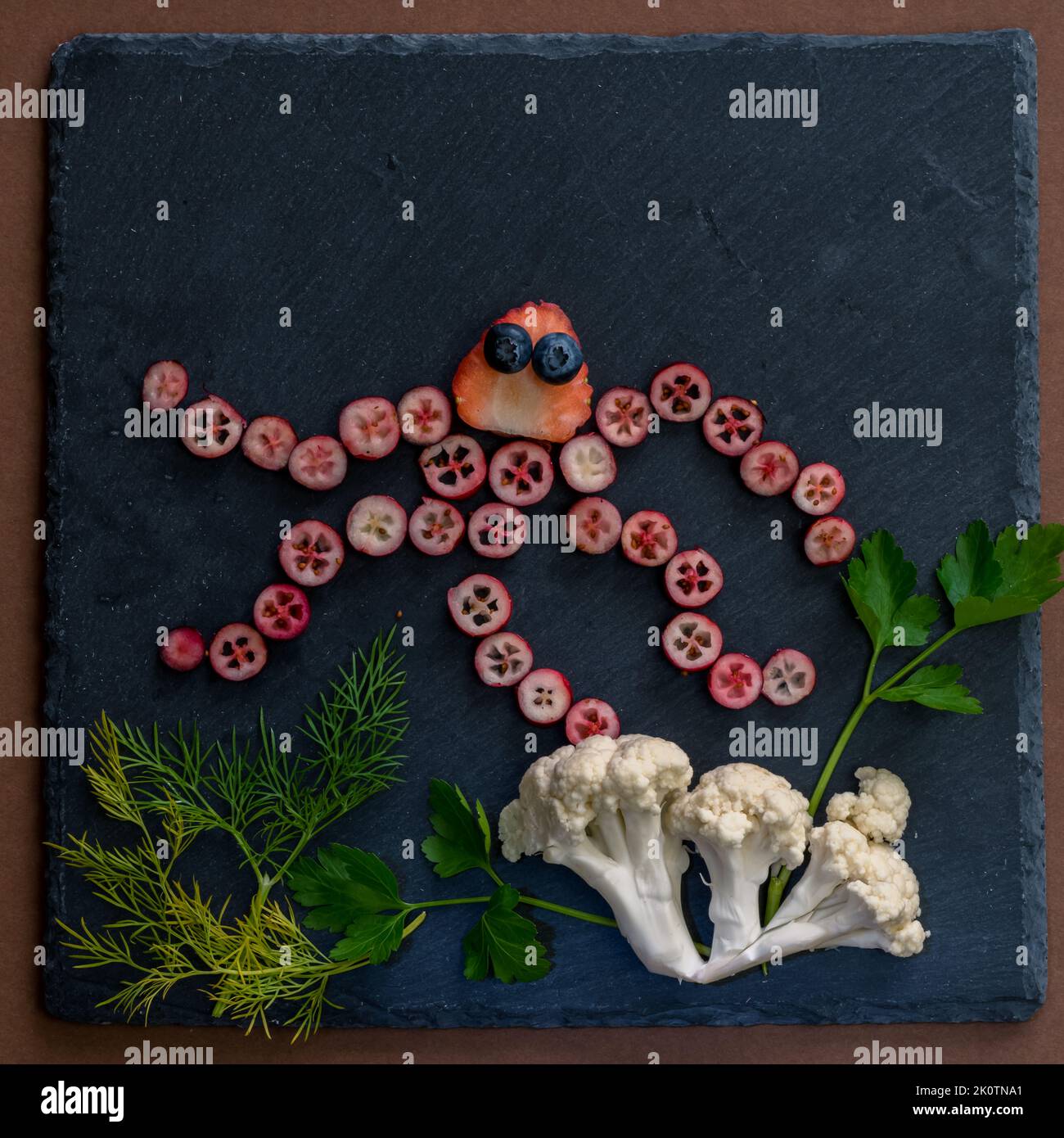octopus made from red fruits on black background Stock Photo - Alamy