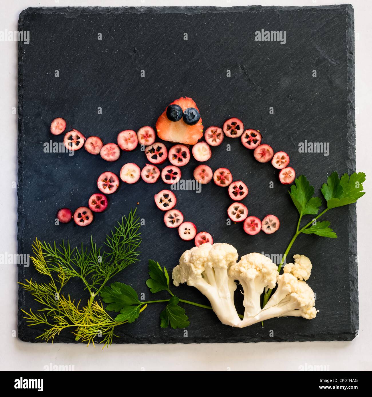 octopus made from red fruits on black background Stock Photo - Alamy