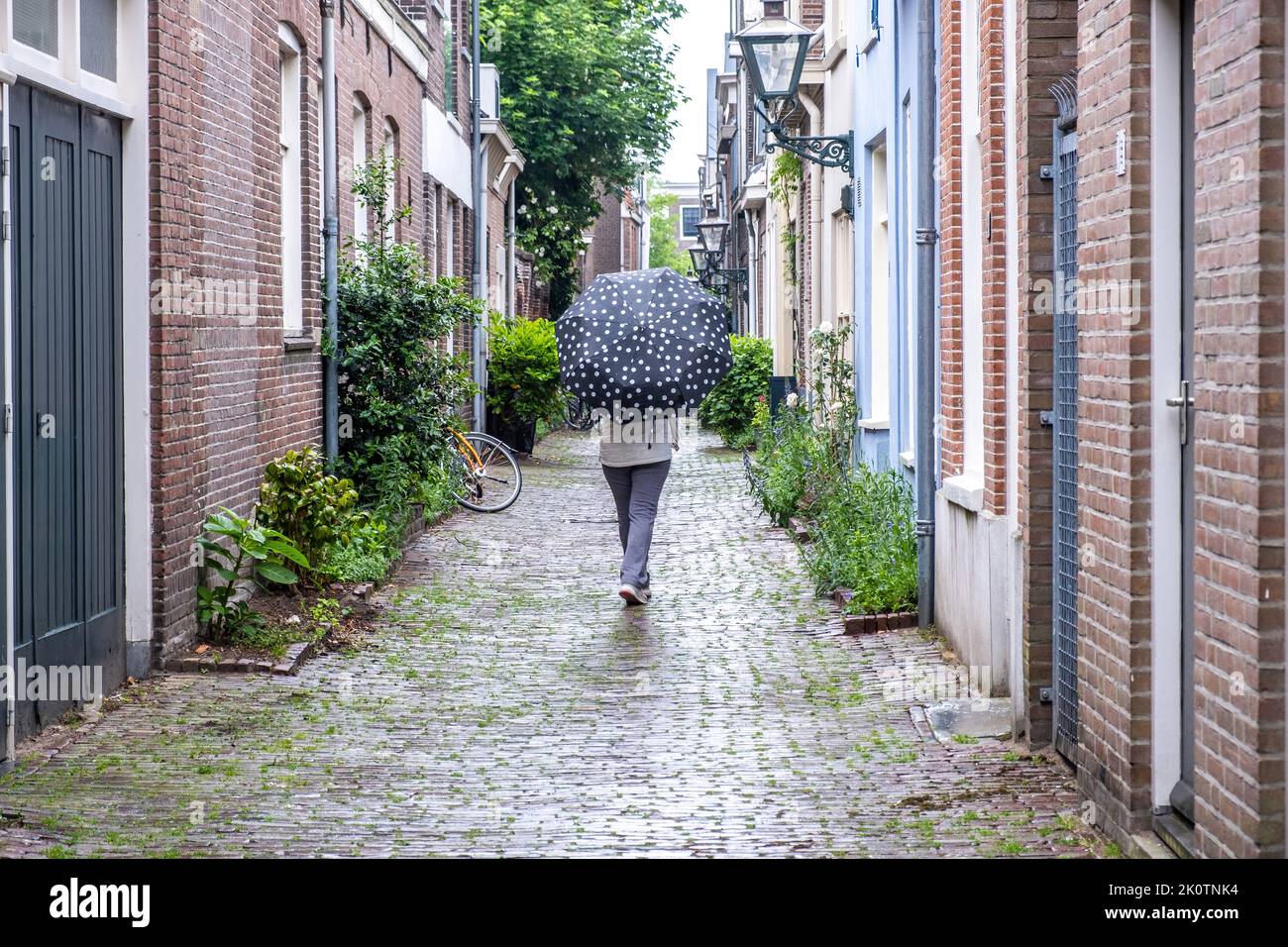 Woman walks between buildings hi-res stock photography and images - Alamy