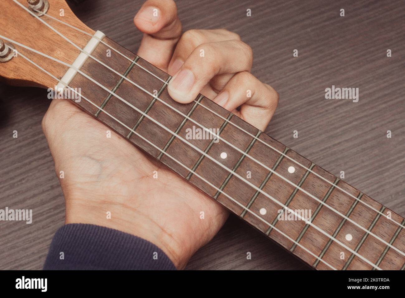 ukulele in close up with hand placing chords. The chord is C. Portable ...