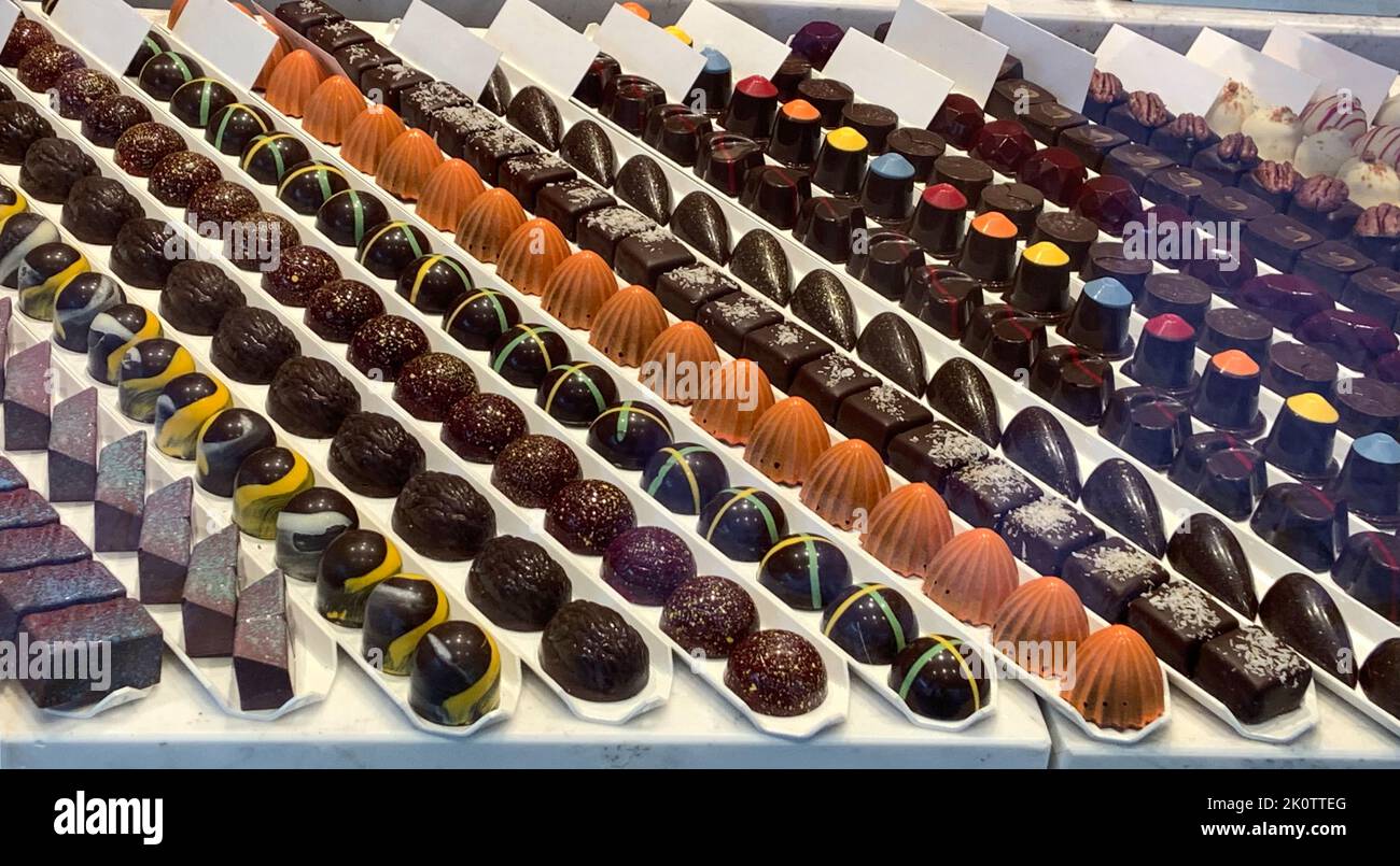 Dark Belgian chocolate sweets in straight lines in the shop window ...