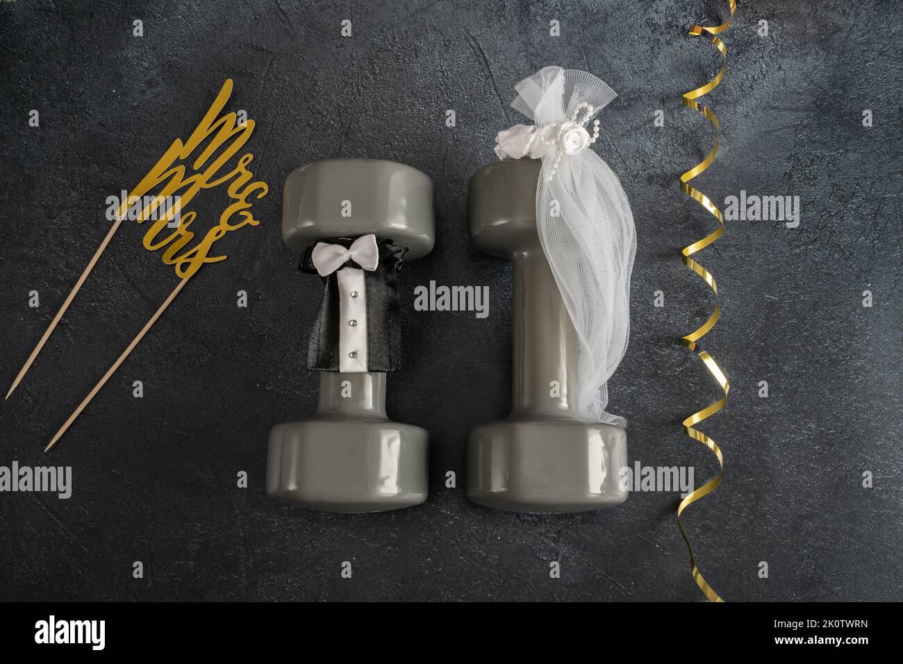 Gym dumbbells stylized as bride and groom, dressed in a small ...